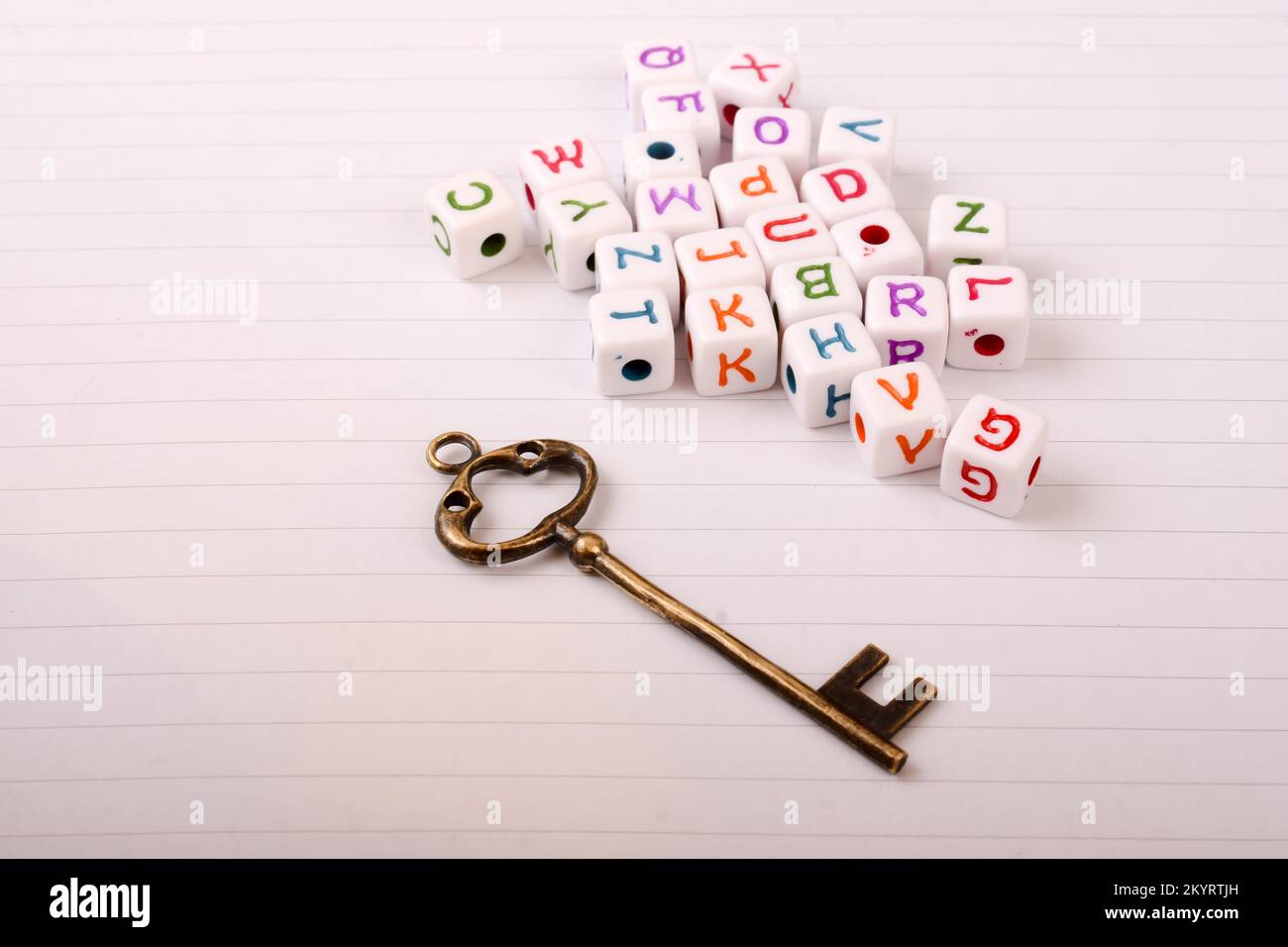A beautiful metal key and cube letters of alphabet side by side on a ...