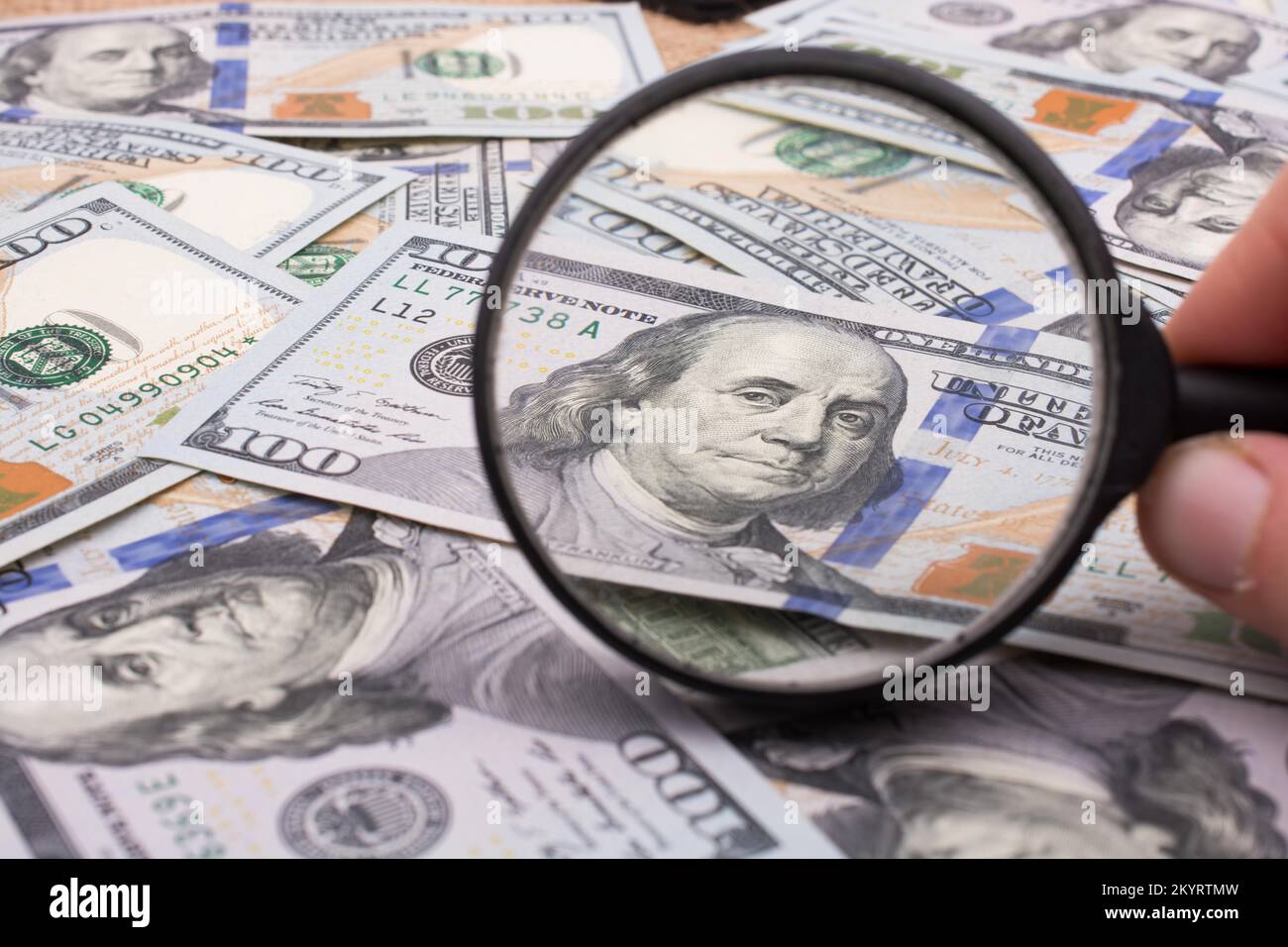 Magnifying glass is held over the banknote bundle of US dollar Stock ...