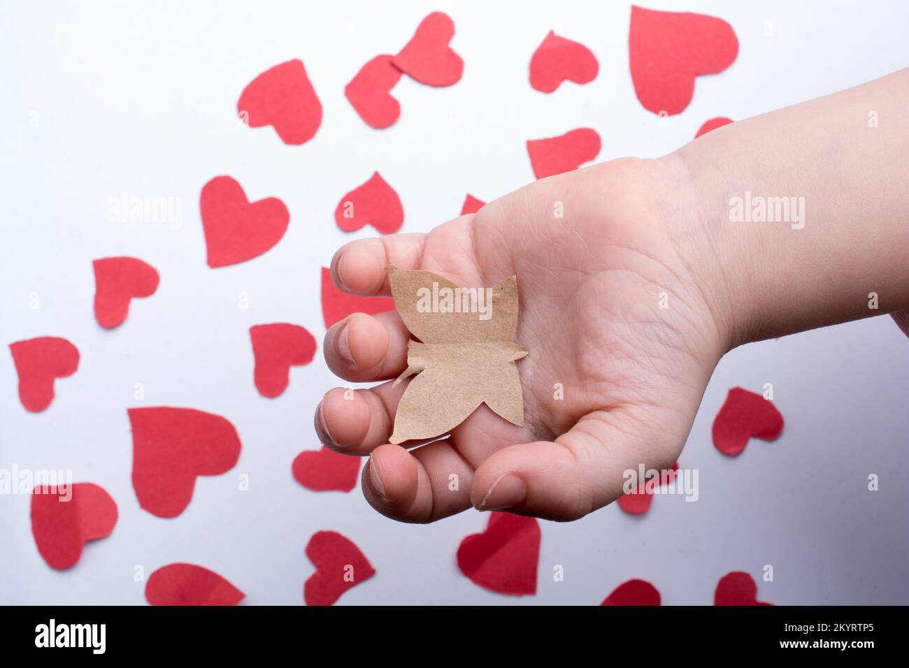 Paper butterfly and red paper hearts in hand Stock Photo - Alamy