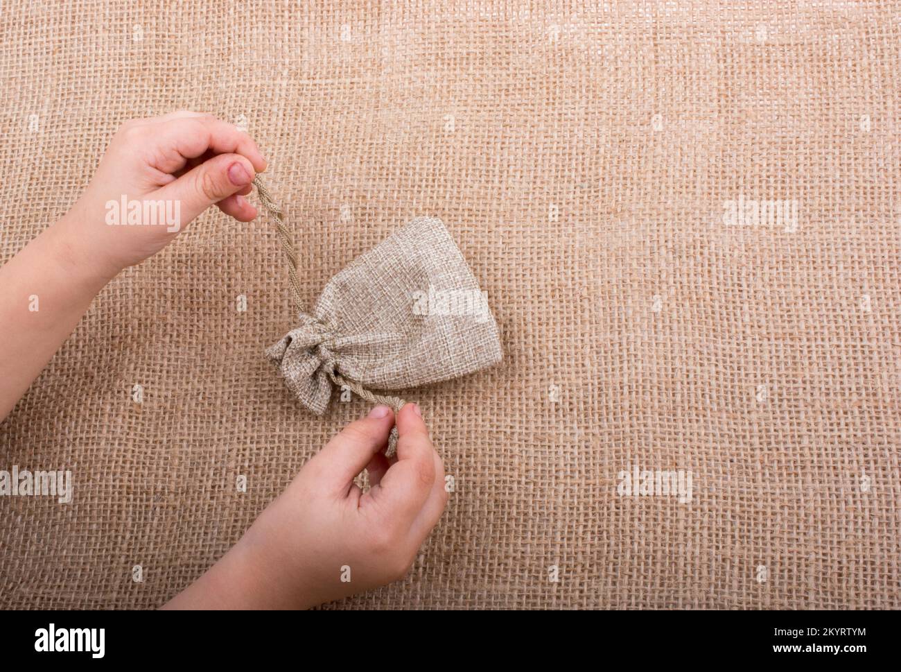 Hand holding an empty little sack made of linen Stock Photo - Alamy