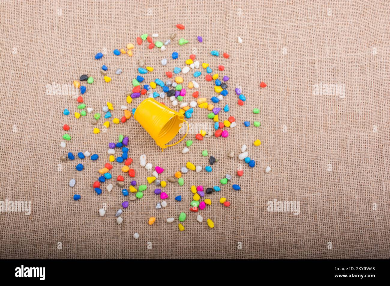 Bucket of colorful pebbles spill on background Stock Photo - Alamy