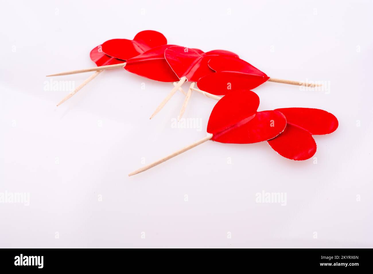 Red hearted sticks scattered on a white background Stock Photo - Alamy