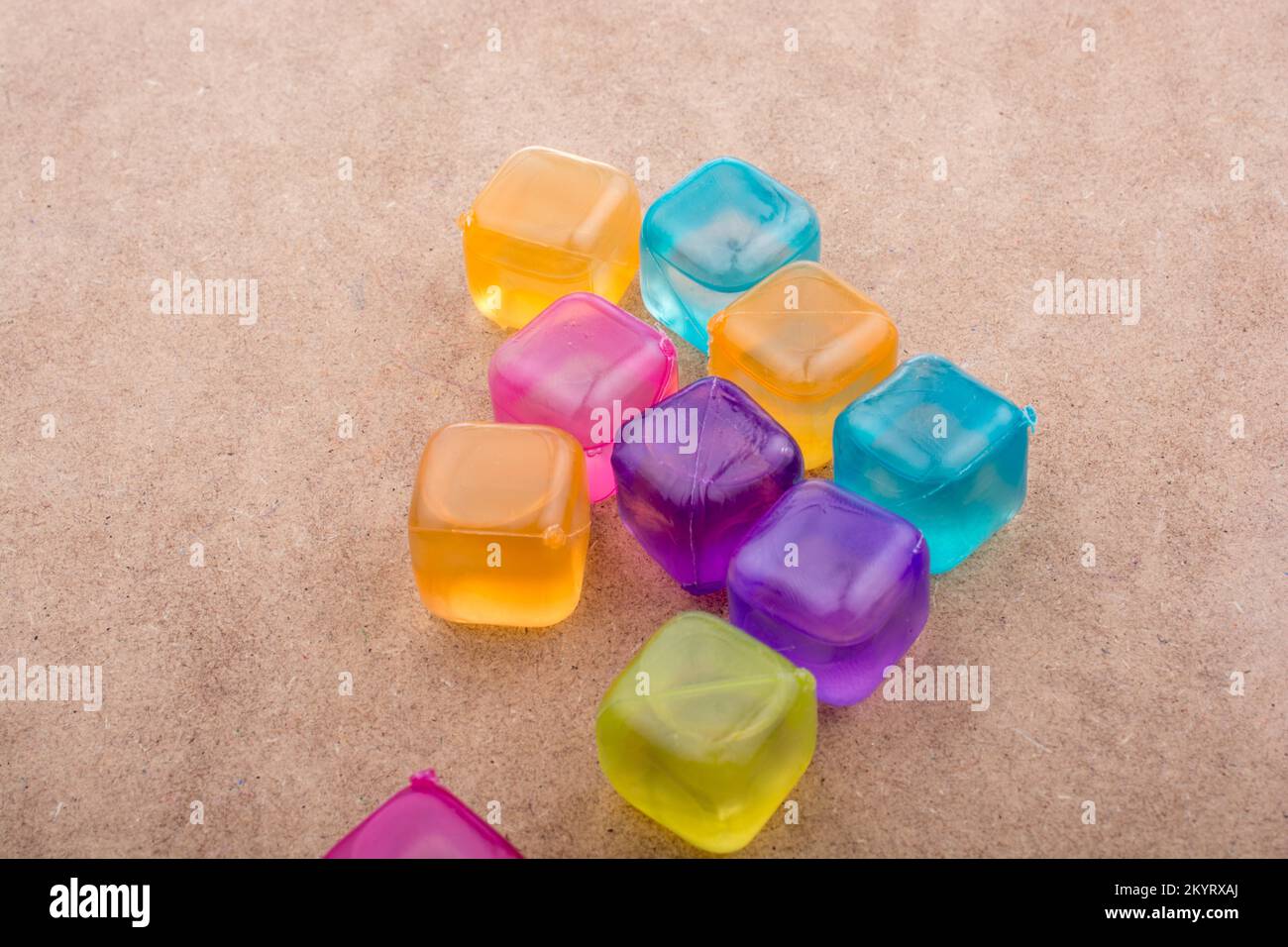 Fake colorful ice cubes on a brown background Stock Photo - Alamy