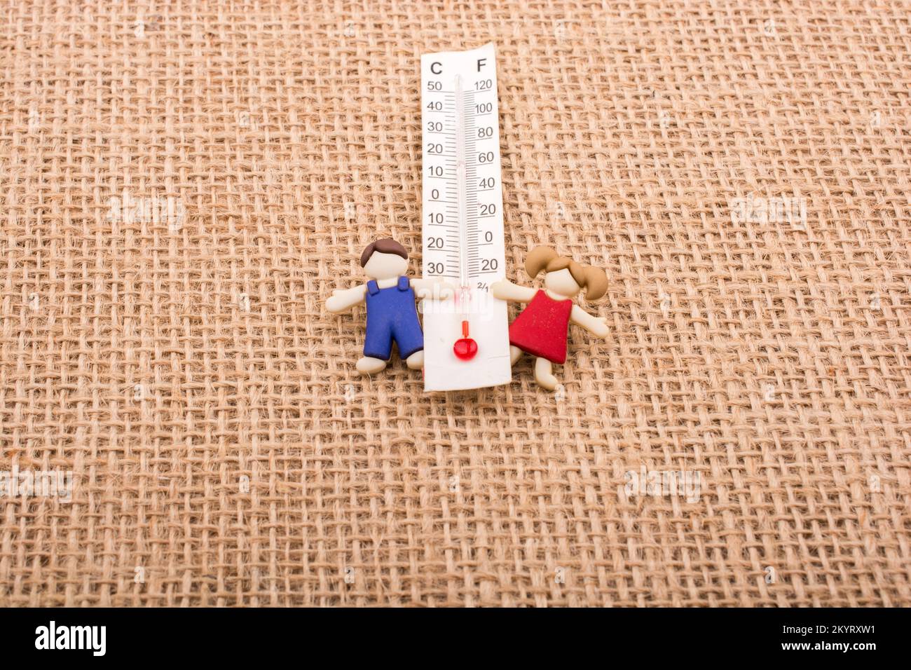 Thermometer placed between a boy and a girl figurine Stock Photo - Alamy