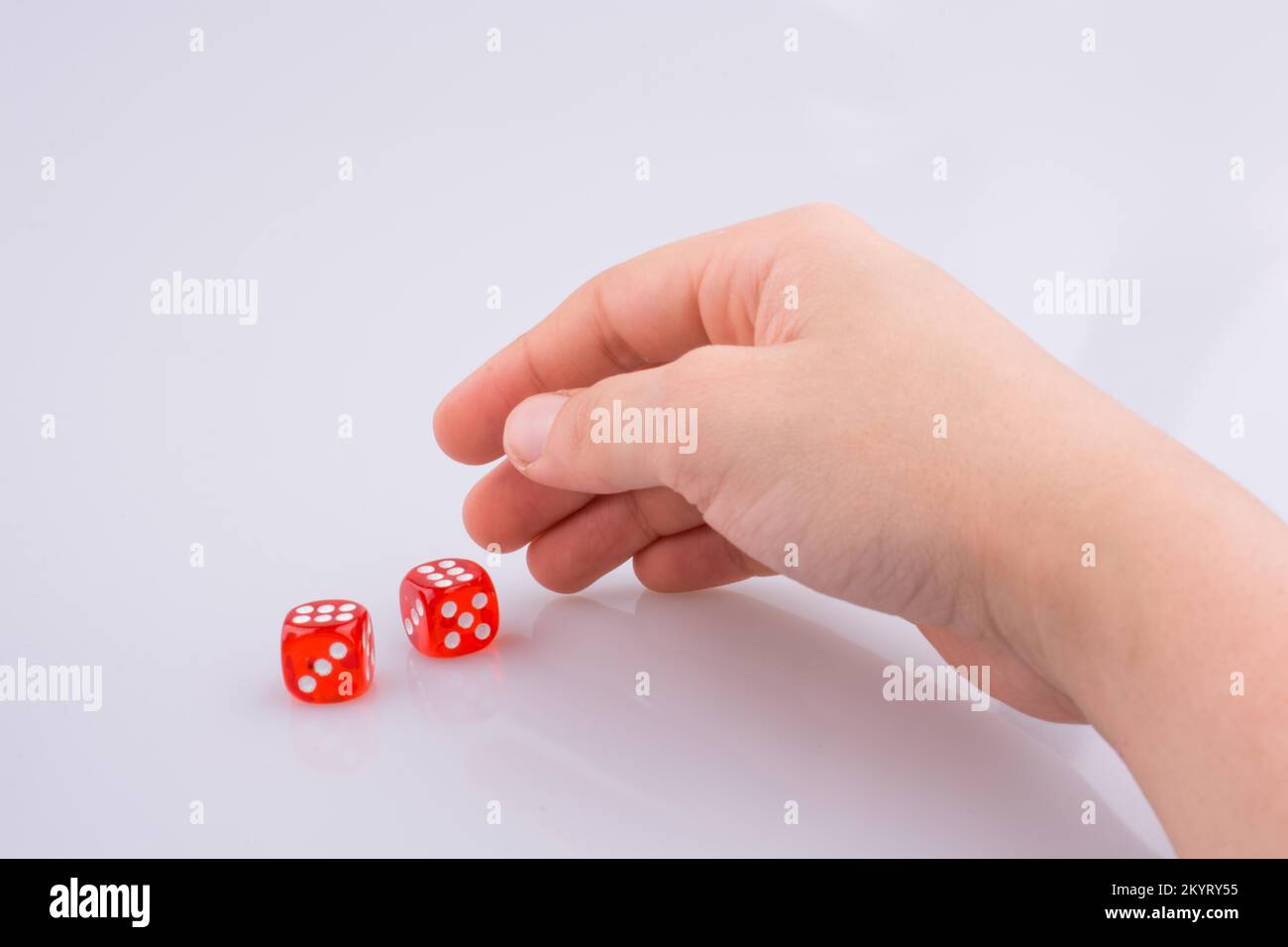 Hand holding red dice on a white background Stock Photo - Alamy
