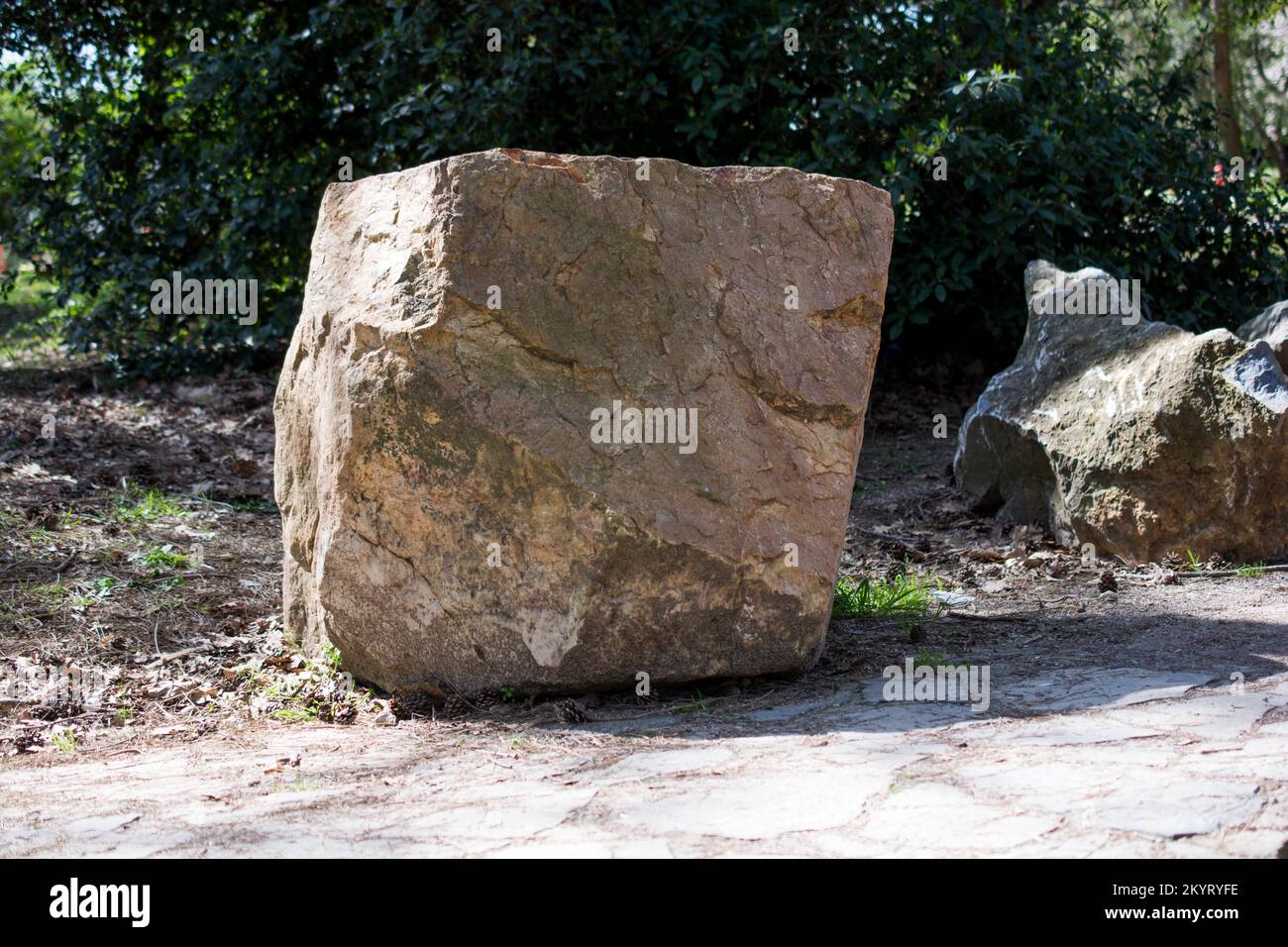 Big rock in garden by the side of a tree Stock Photo - Alamy