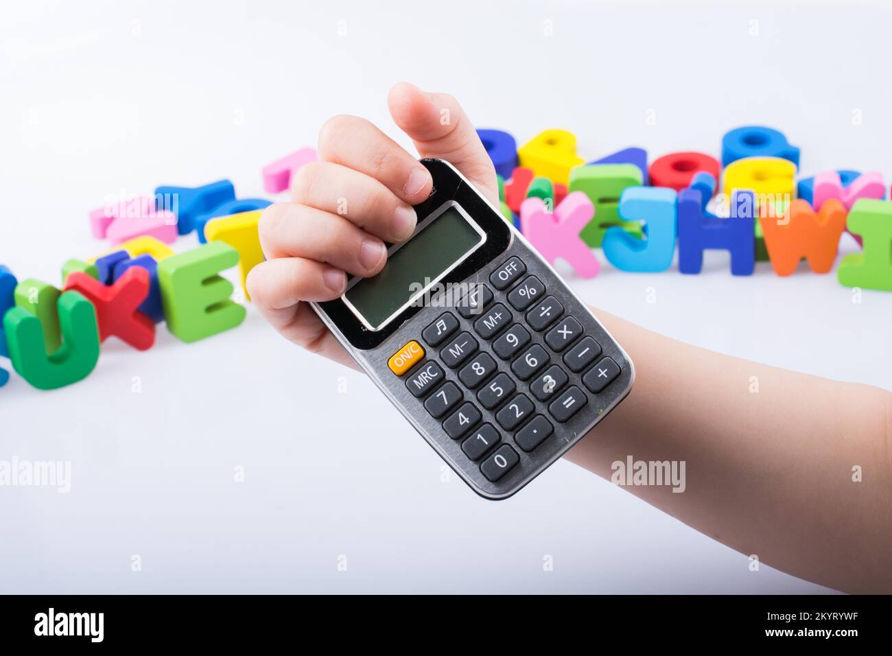 Little calculator in hand with colorful letters behind on white Stock ...