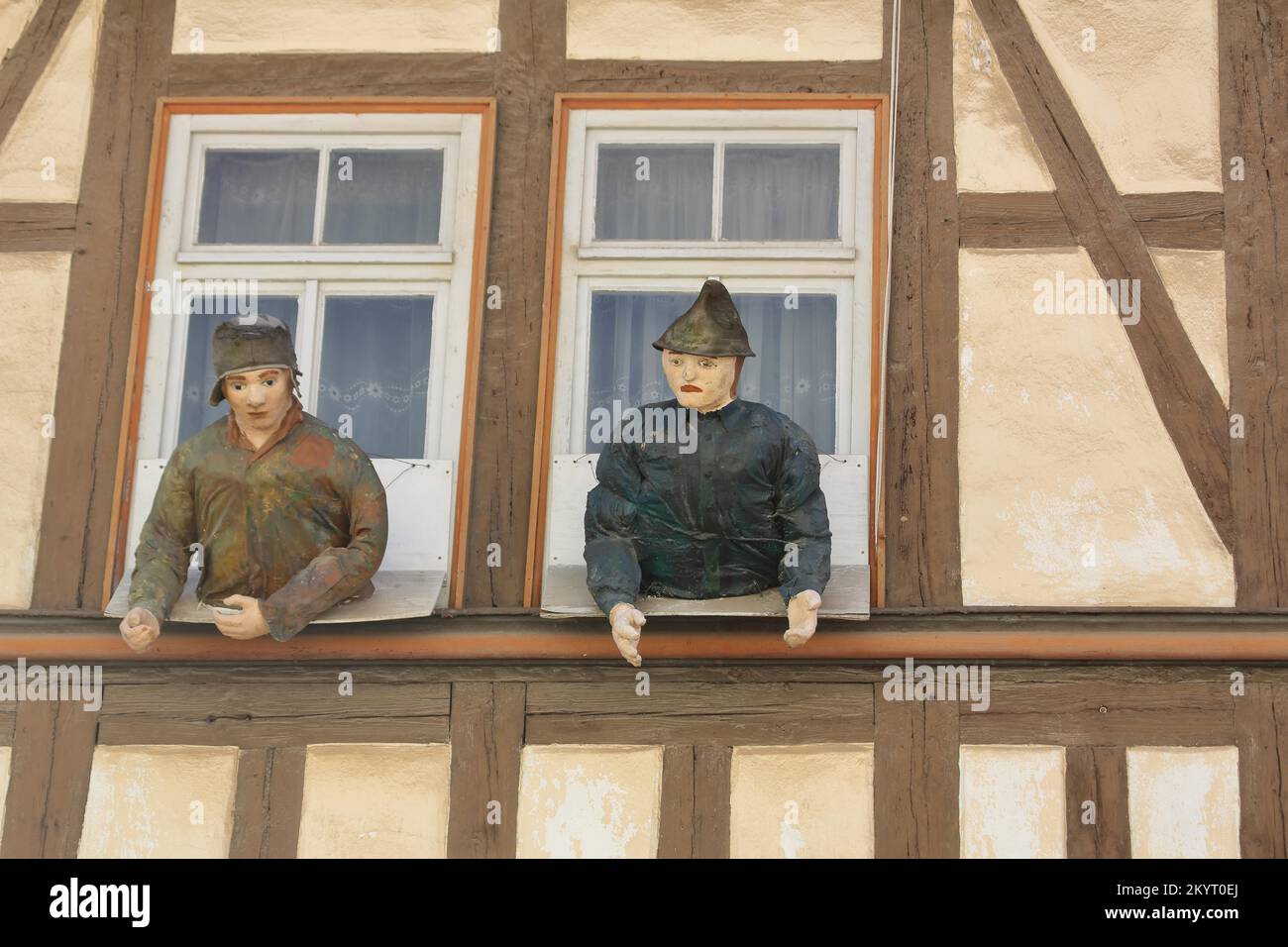 Two dolls figures looking out of the window of the house, looking out ...
