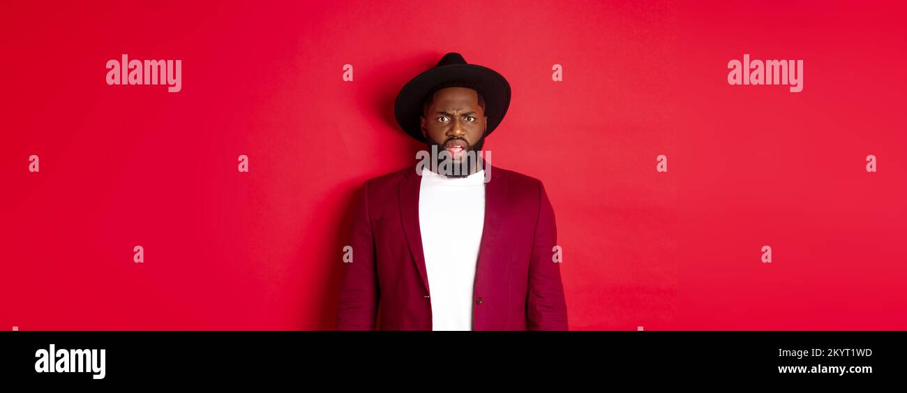 Fashion and party concept. Confused Black man in classy outfit frowning ...