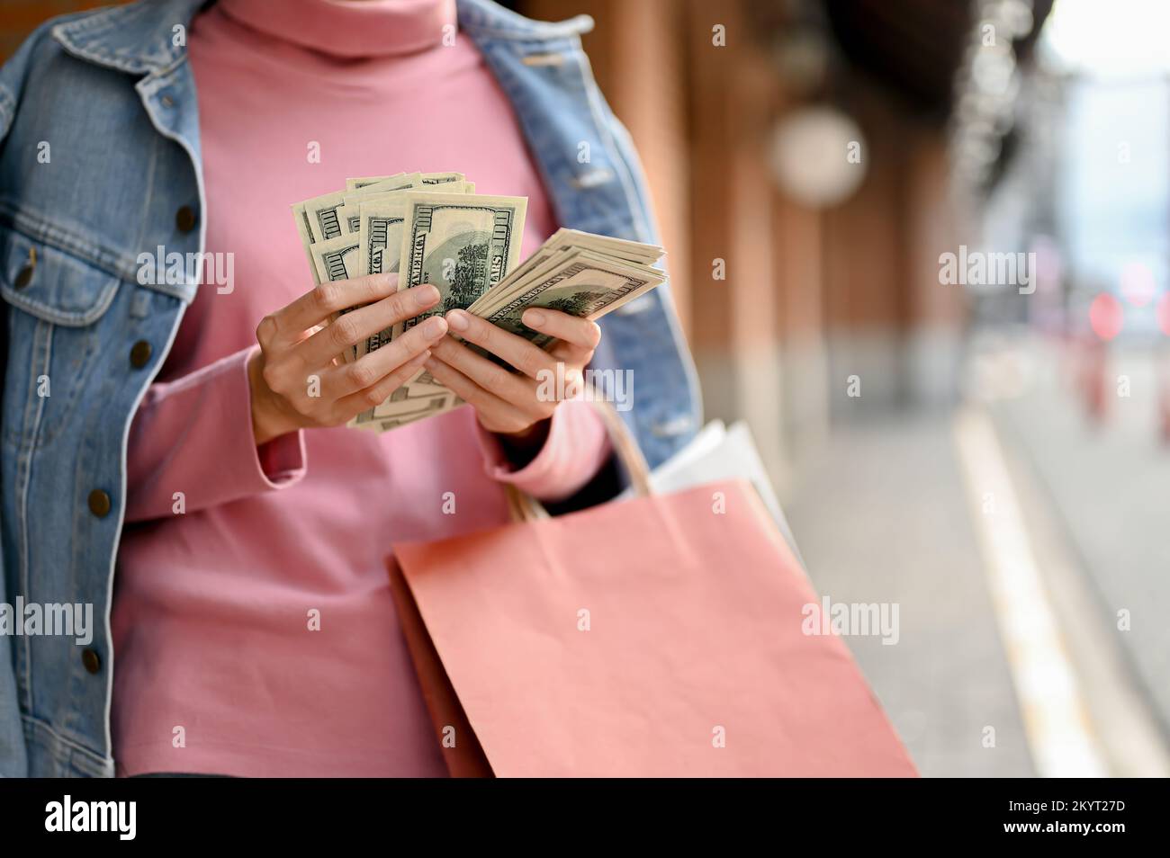 Gorgeous and rich woman holding US dollar banknotes, counting her cash ...