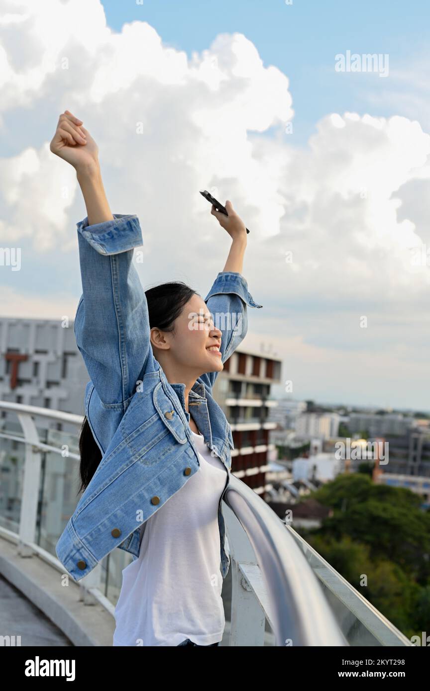 Portrait, Beautiful young Asian woman hands up in the air, raising ...