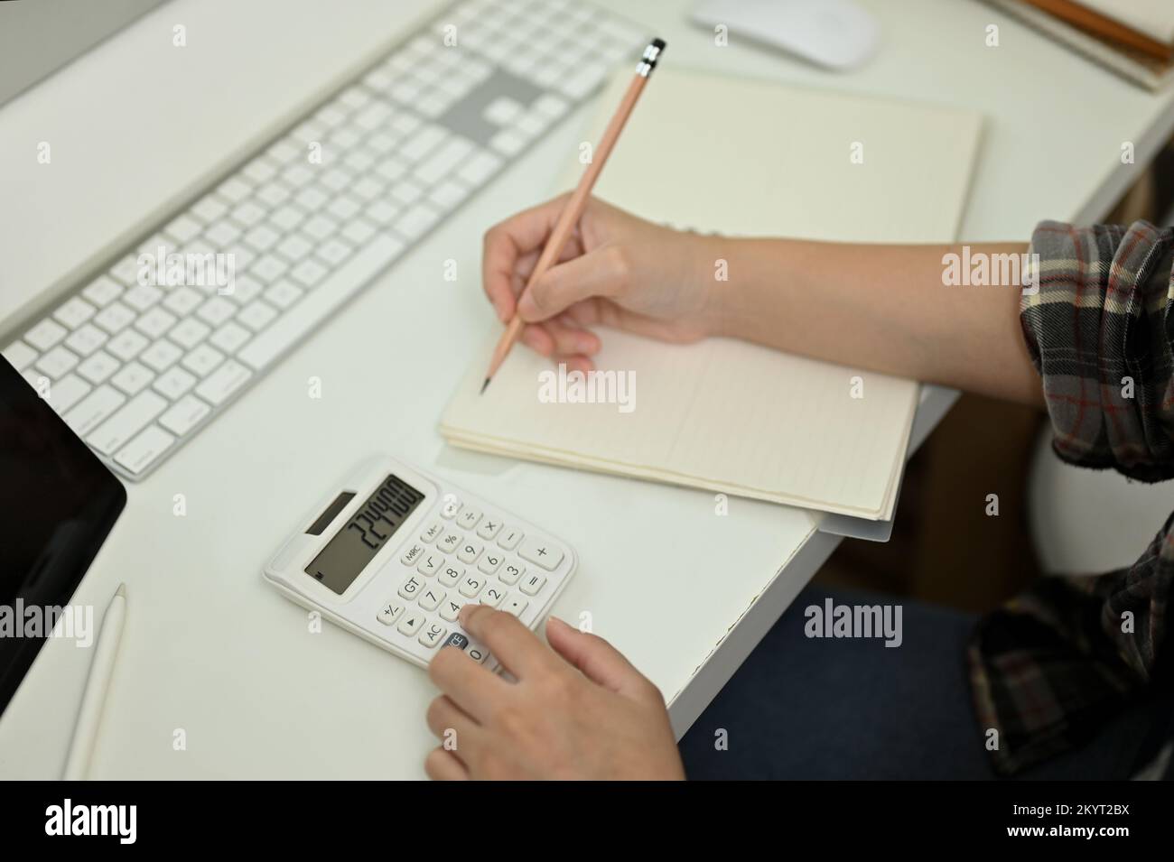Top view, A female accountant taking notes on her notebook, using ...