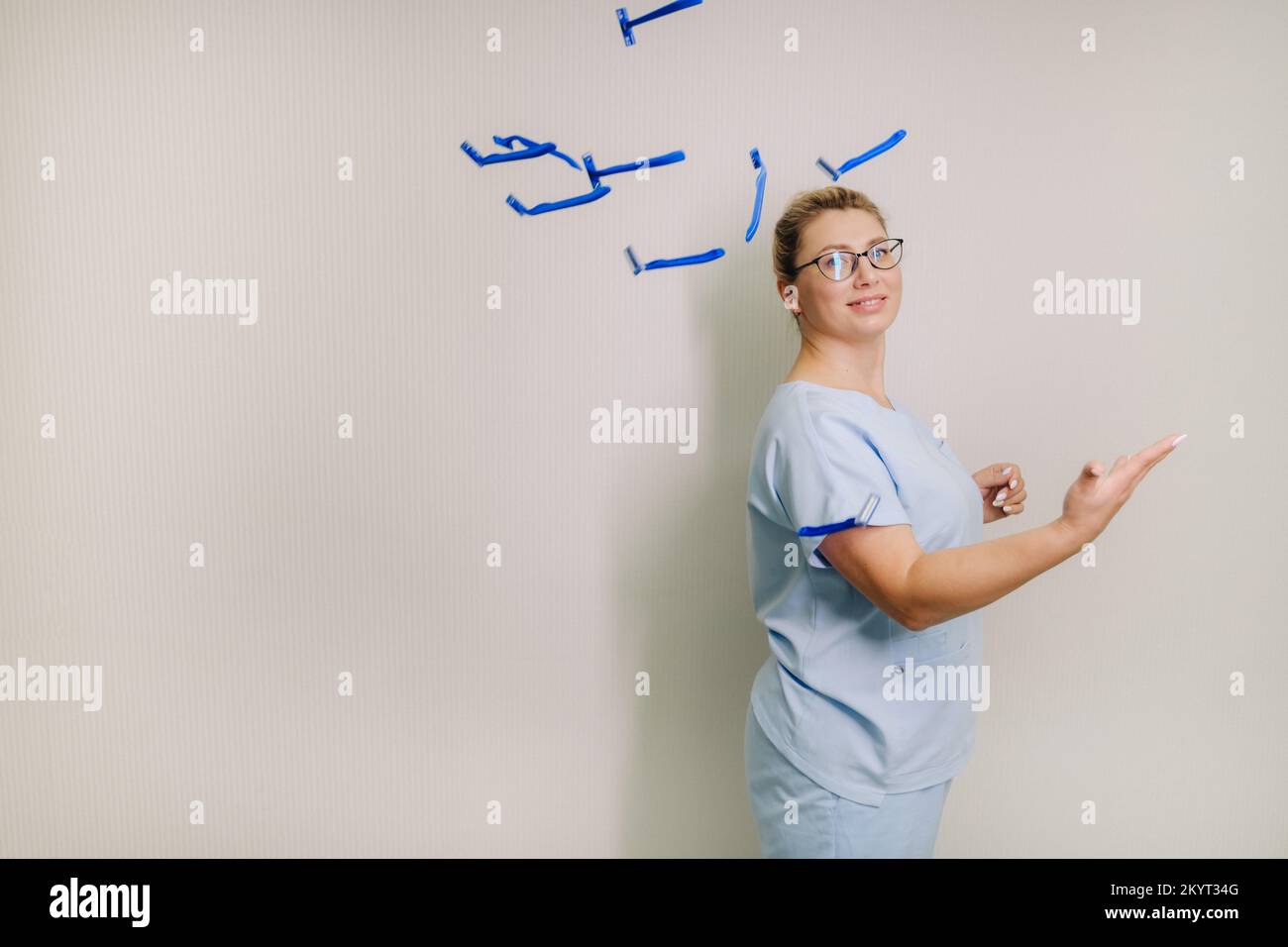 a female laser hair removal master in a blue robe throws shaving ...