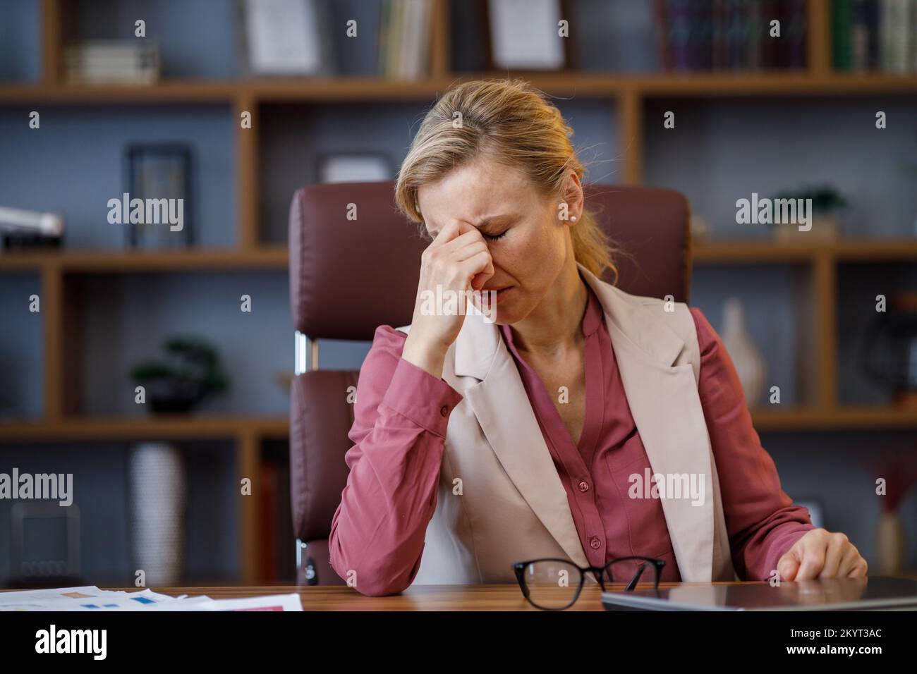Tired businesswoman after exhausting paperwork taking off eyeglasses ...