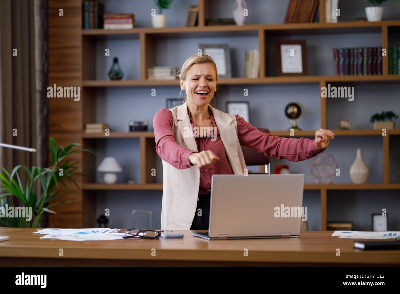 Female trader dancing at workplace. Happy businesswoman got positive ...