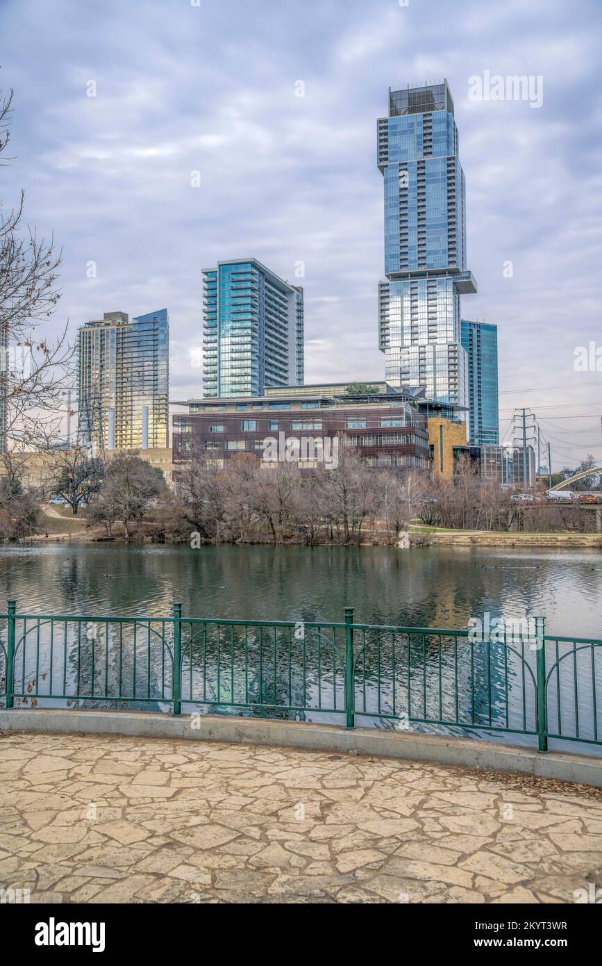 Austin Texas downtown skyline against cloudy sky with pond and park ...