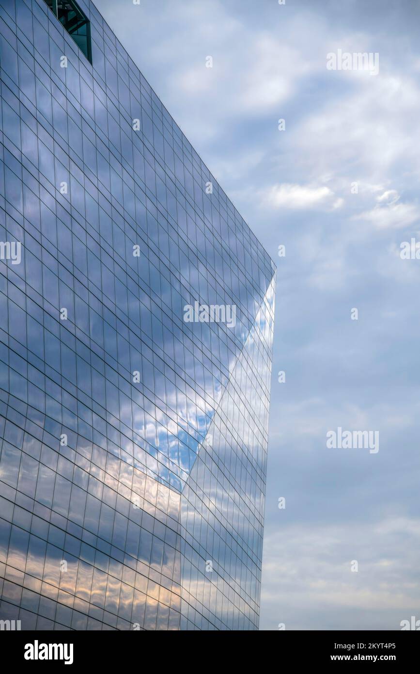 Modern glass building with cloudy sky reflected on the windows in ...