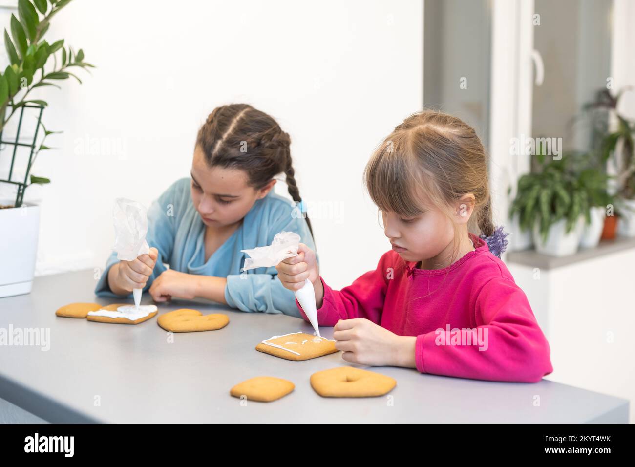 two cute sisters make and decorate cookies Stock Photo - Alamy