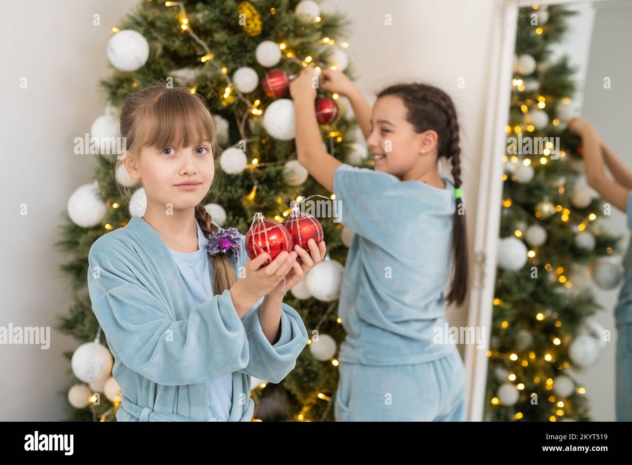 Two cute little girls under Christmas tree. Children under Christmas ...
