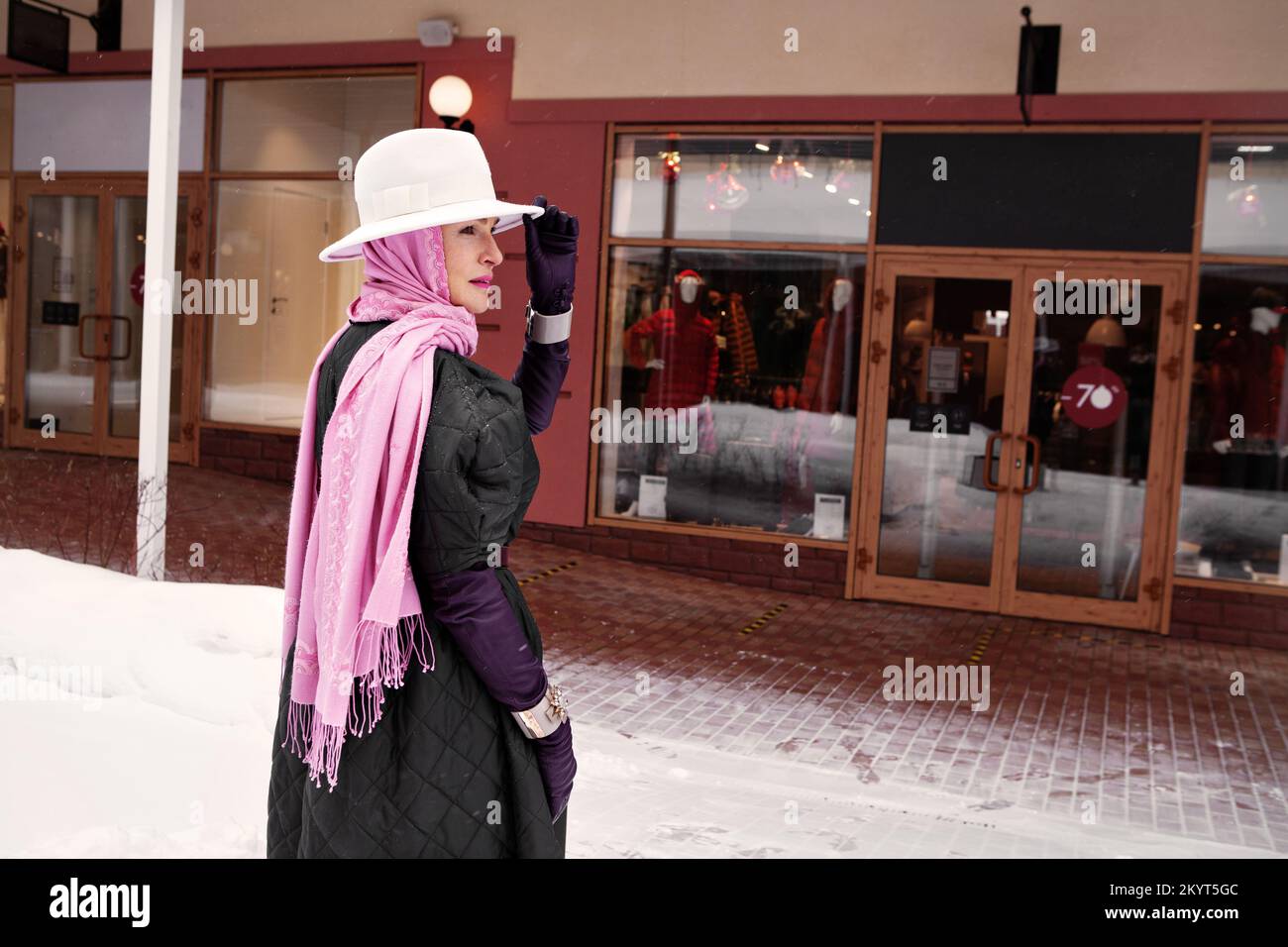 Elegant mature woman in stylish outfit shopping near discount clothing ...