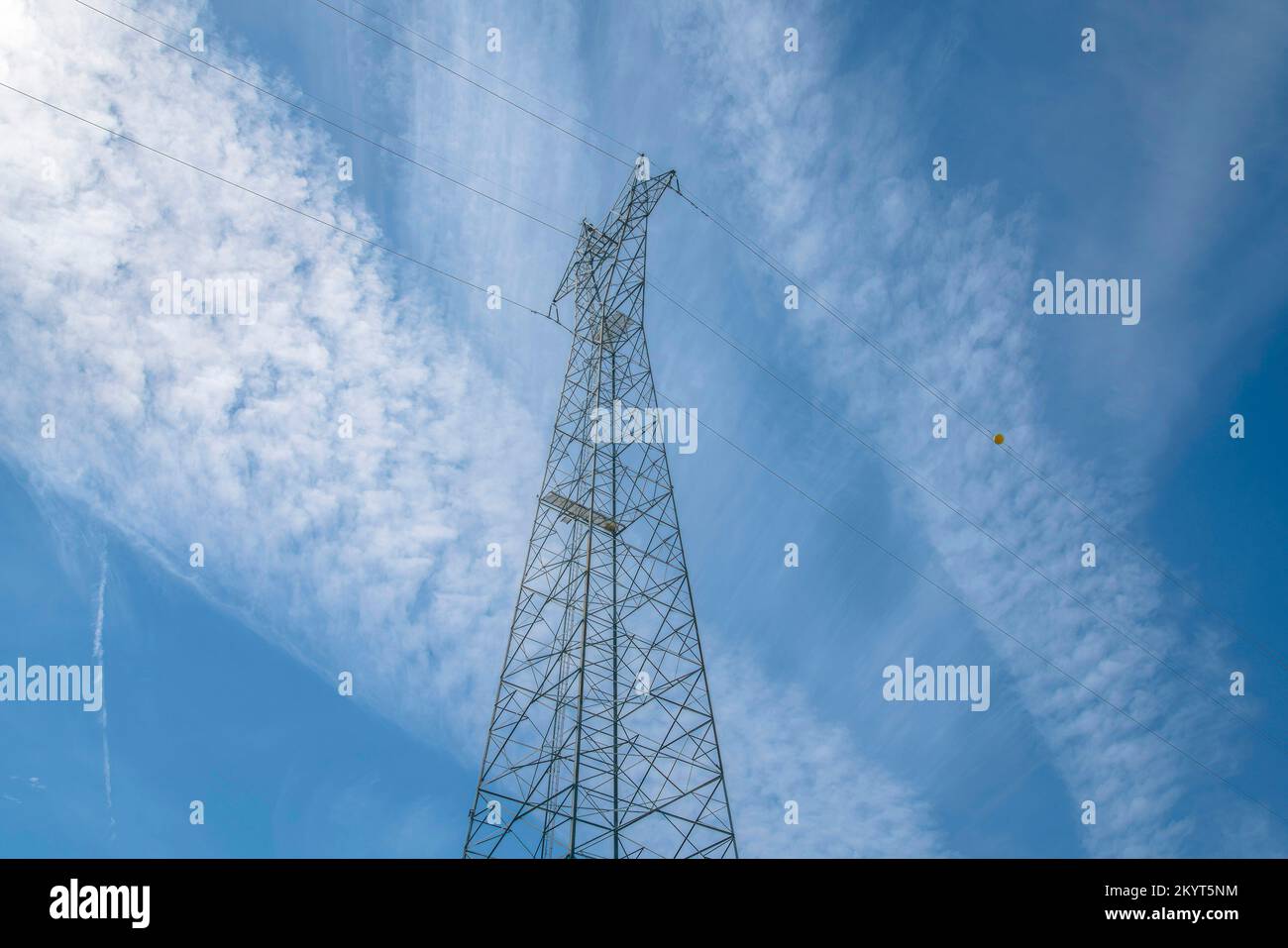 High voltage electricity tower and power lines against blue sky in ...