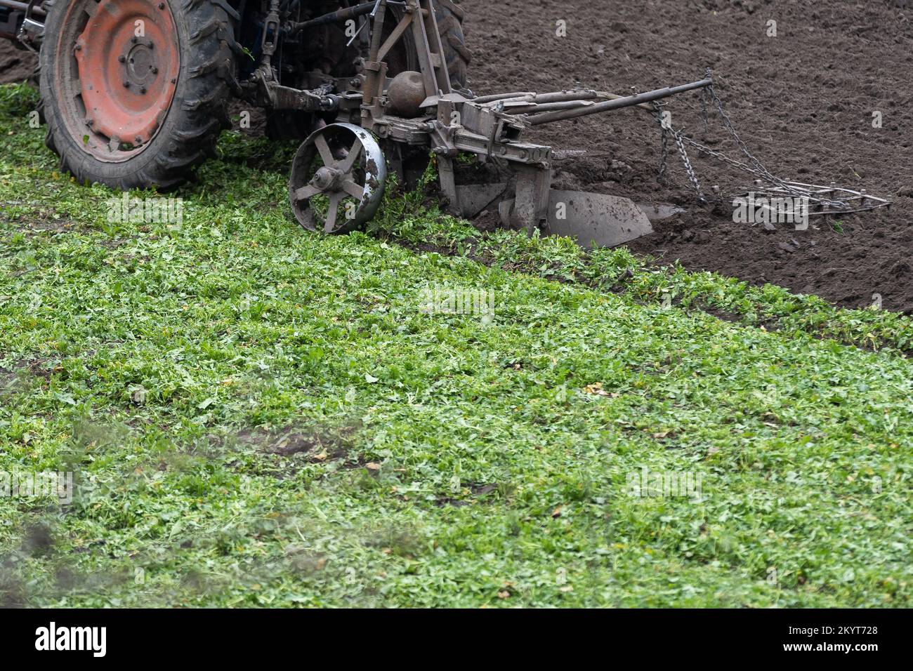 farm tractor with plow plows the field and prepares for sowing Stock ...