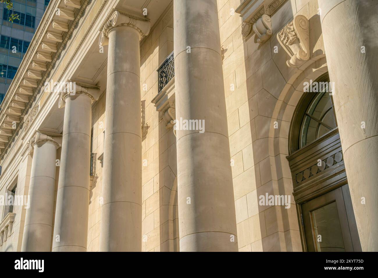 Exterior of a building with huge circular columns and brown wooden door ...