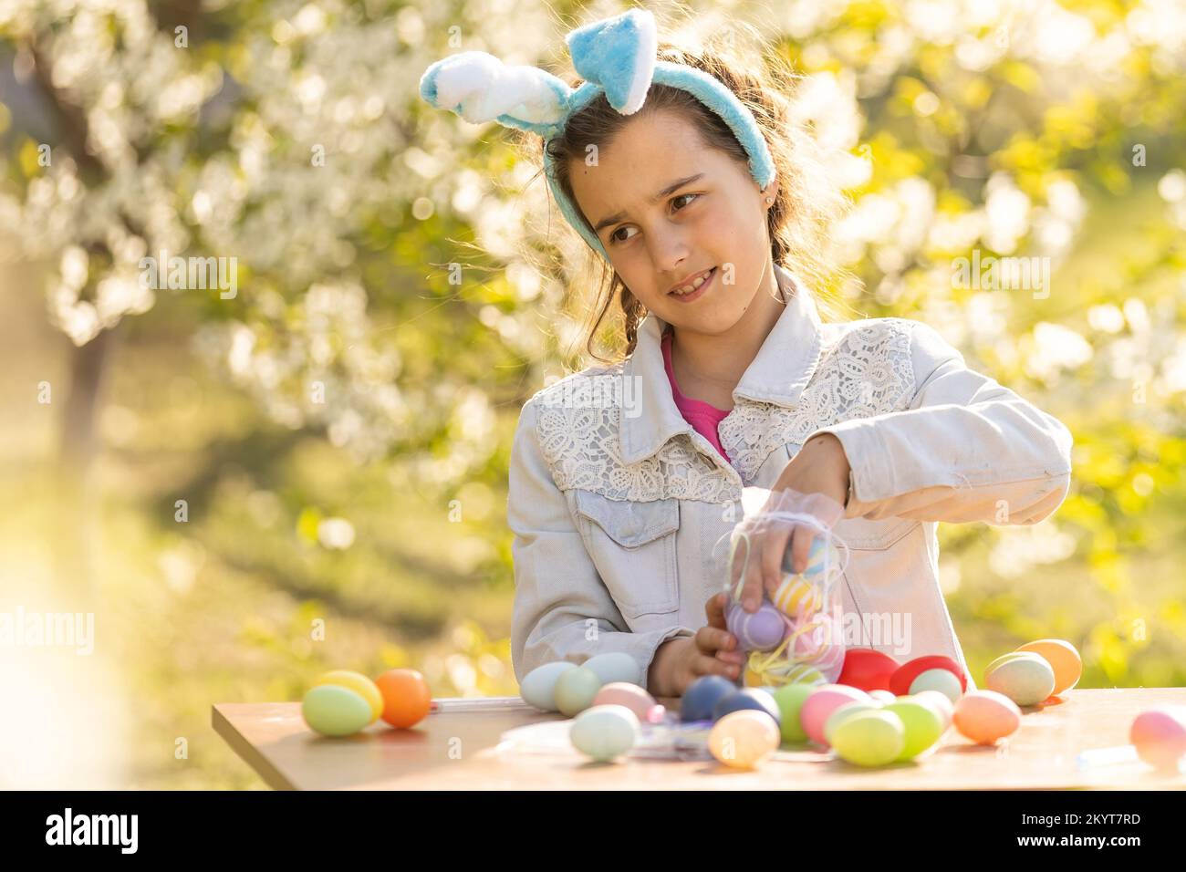 portrait of smiling young girl wearing traditional bunny ears headband ...