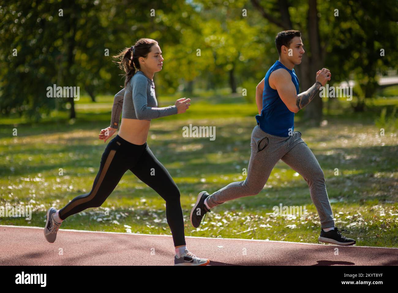 A good looking male and attractive female are running together in a ...