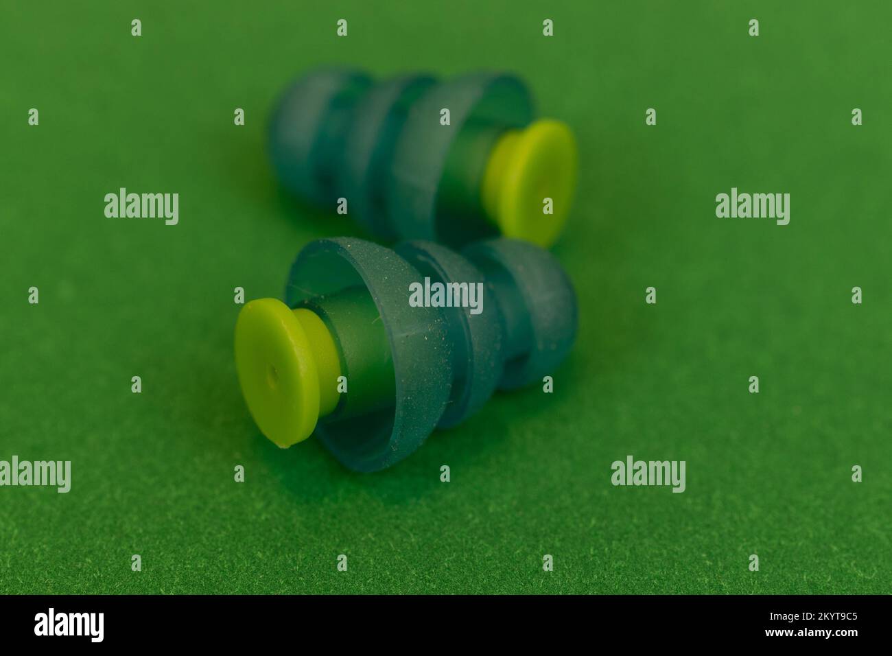 Silicone reusable ear plugs for human ears on green background Stock ...
