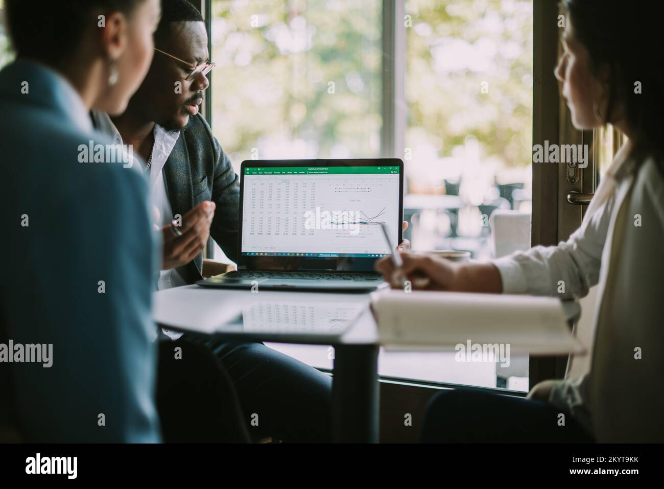 Three bussinesspeople looking at statistics and charts for their recent ...
