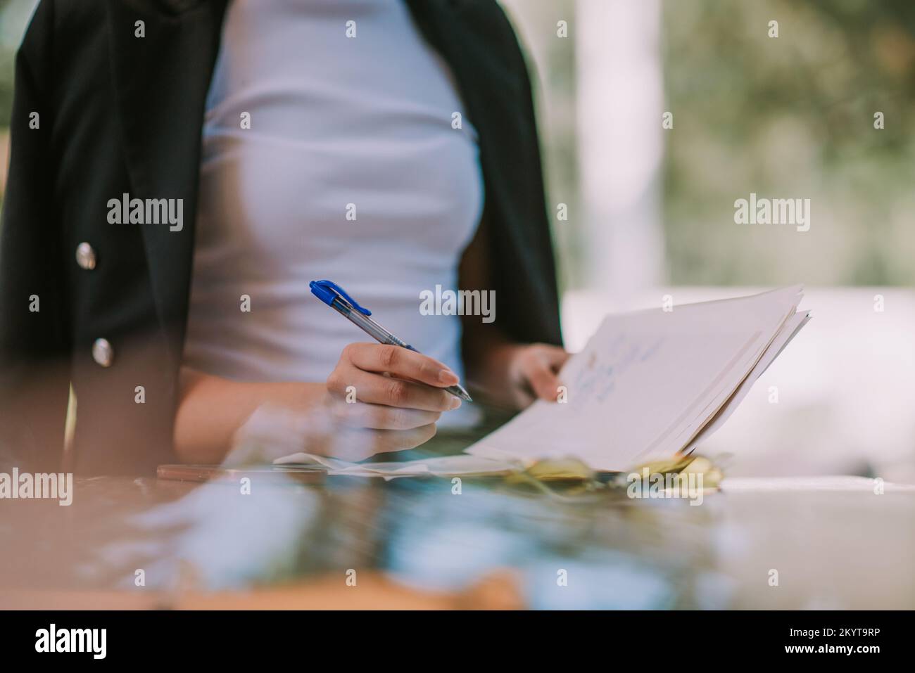 Business woman writting in the notebook while standing Stock Photo - Alamy