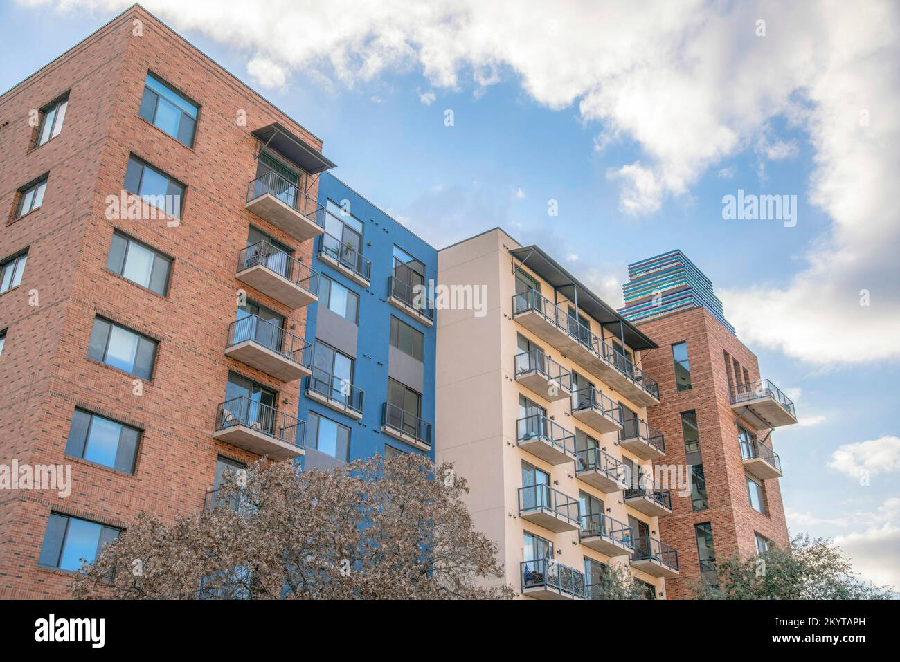 Residential building with balconies and red brick wall against sky and ...