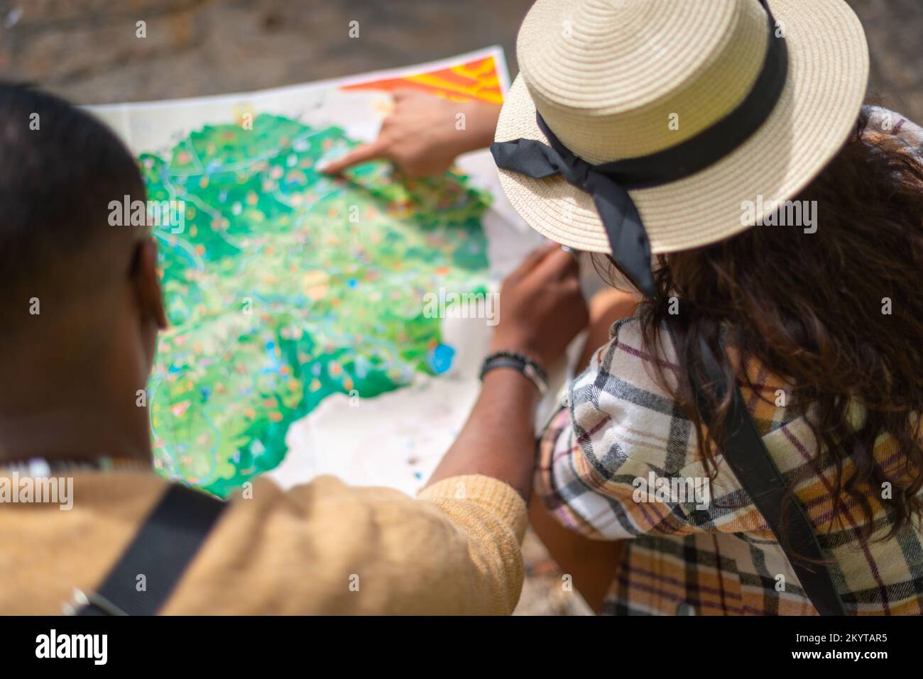 A male is looking at the map where his girlfriend is pointing. The next ...