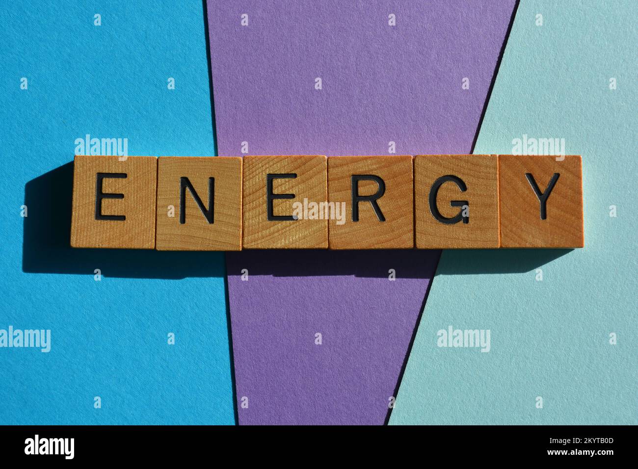 Energy, word in wooden alphabet letters isolated on blue and purple ...