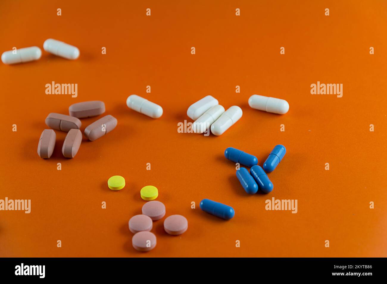 Different pills of brown white blue and yellow color scattered on ...