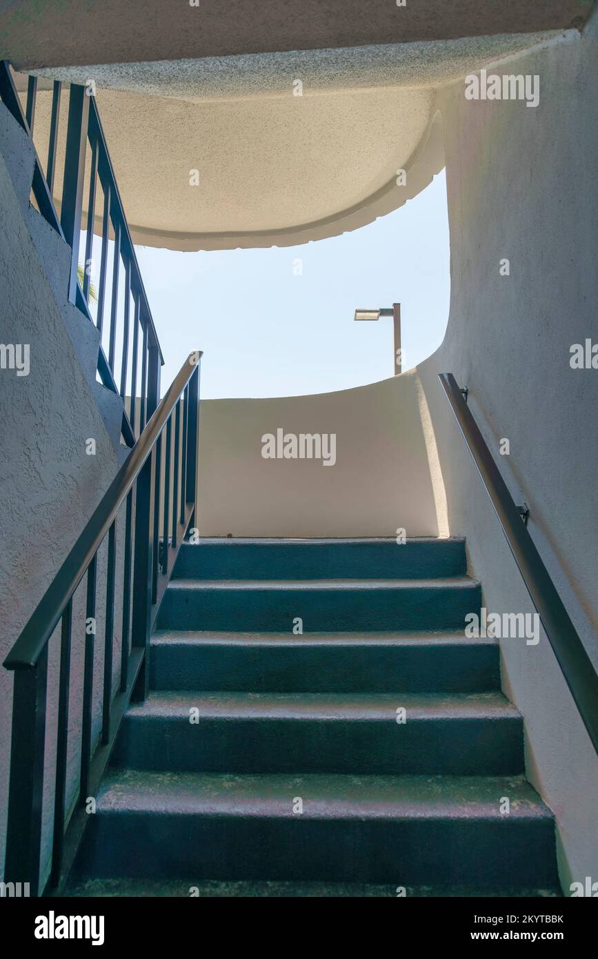 Stairs inside a building with concrete steps and metal railing in ...