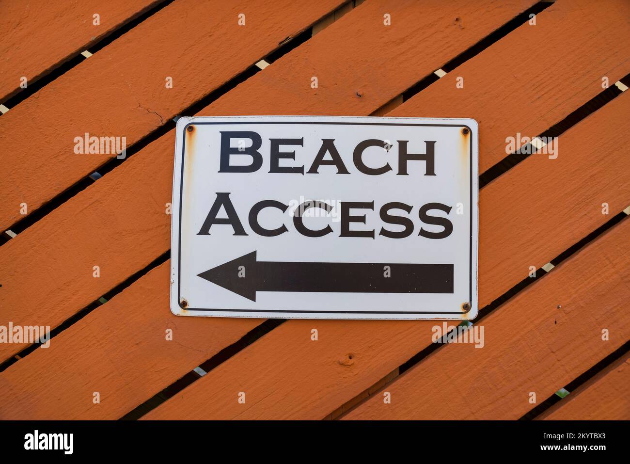 Beach access sign with directional arrow against brown wall in Destin ...