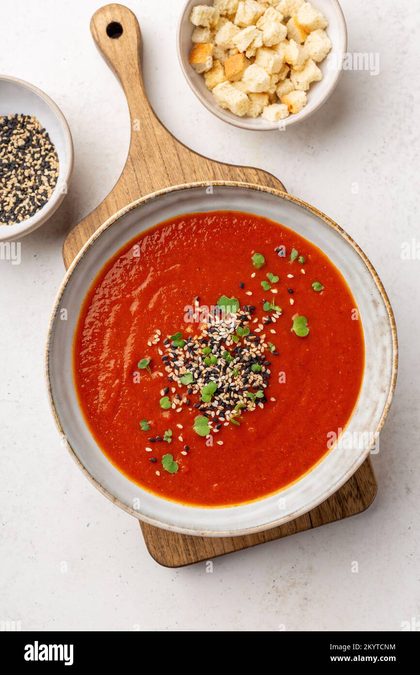Creamy warm tomato soup served with sesam seeds and micro greens ...