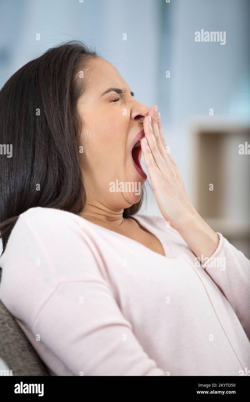side view of woman yawning Stock Photo - Alamy