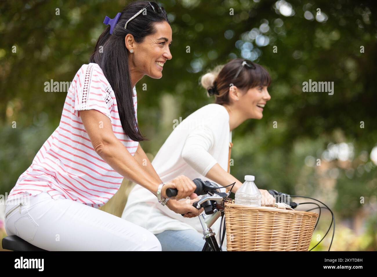 two friends on bikes outdoors smiling Stock Photo - Alamy