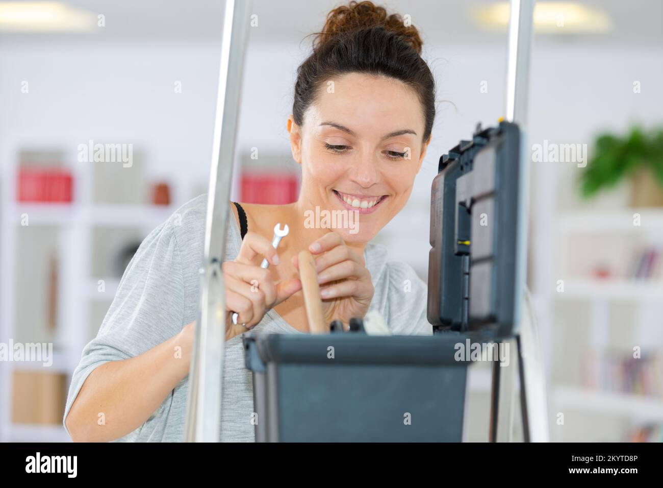 young woman picking up tools in toolbox Stock Photo - Alamy