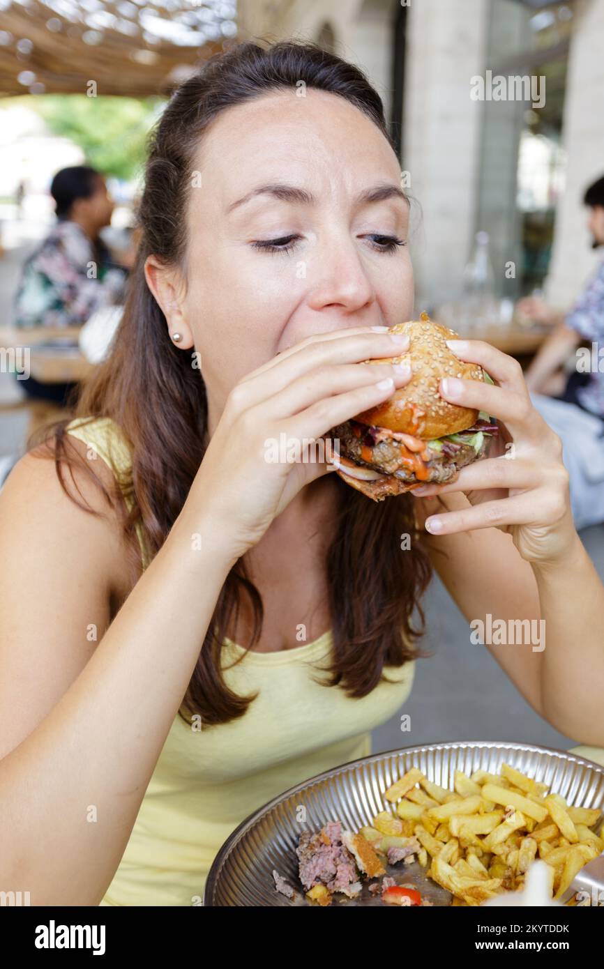 woman eats fast food burger Stock Photo - Alamy