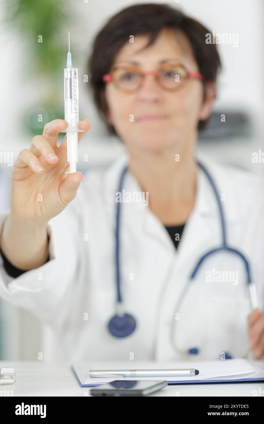 mature doctor showing hand press syringe Stock Photo - Alamy