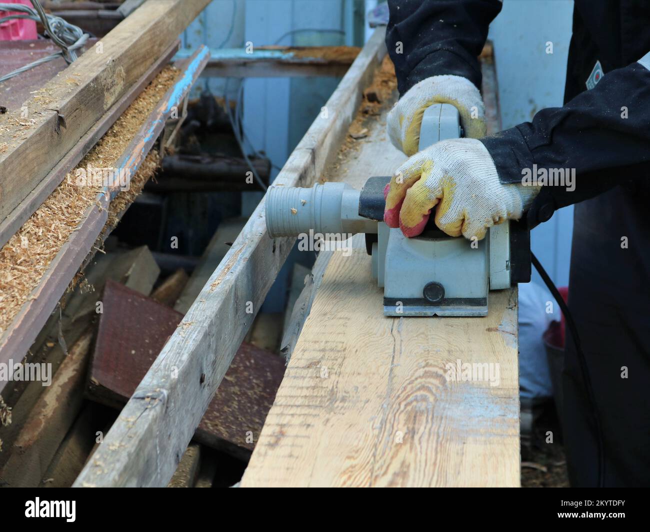 carpenter working with electric planer in the open workspace of the ...