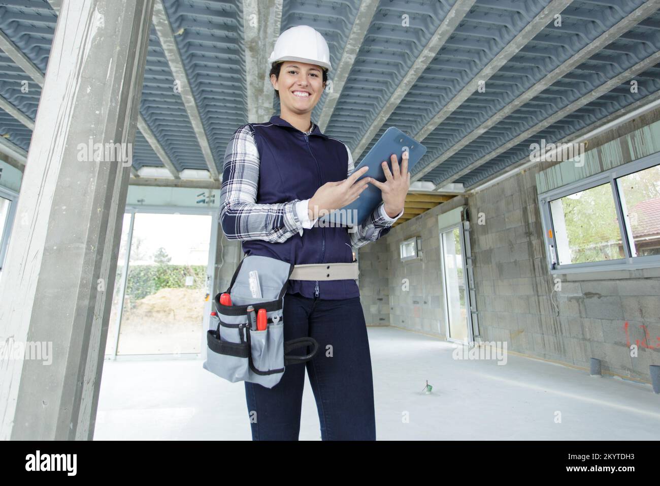 female contractor on construction site holding clipboard Stock Photo ...
