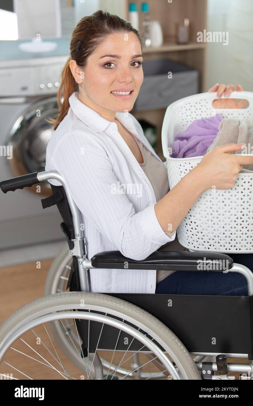 woman in a wheelchair doing laundry Stock Photo - Alamy