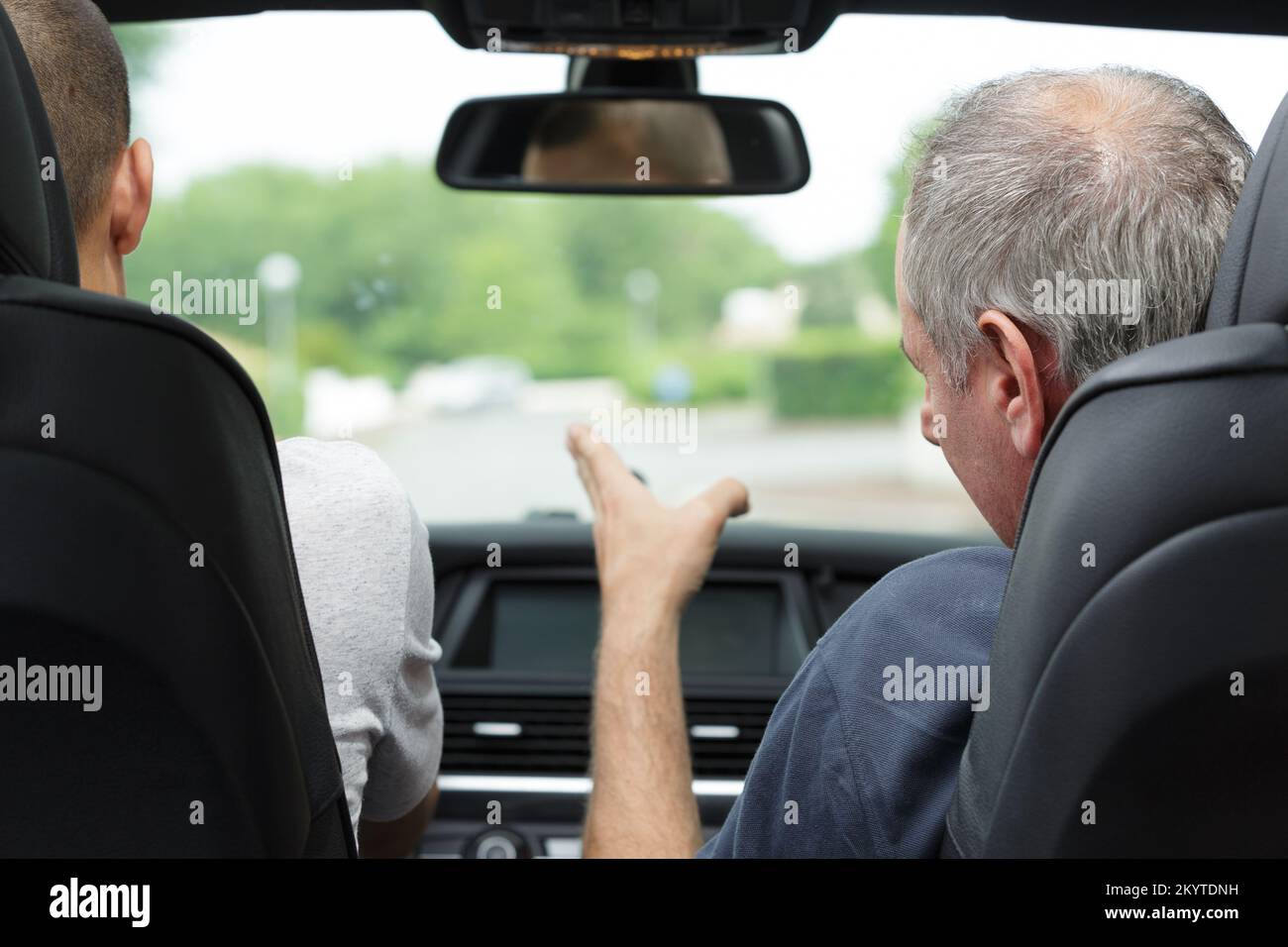 two men talking in the front of a car Stock Photo - Alamy