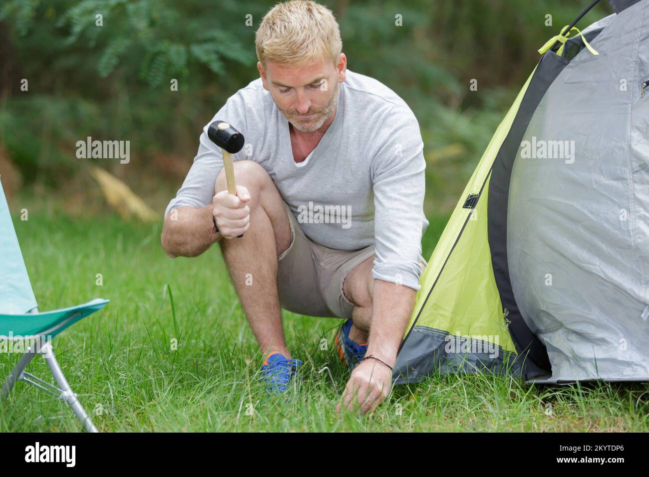 man setting up the tent at campsite Stock Photo - Alamy