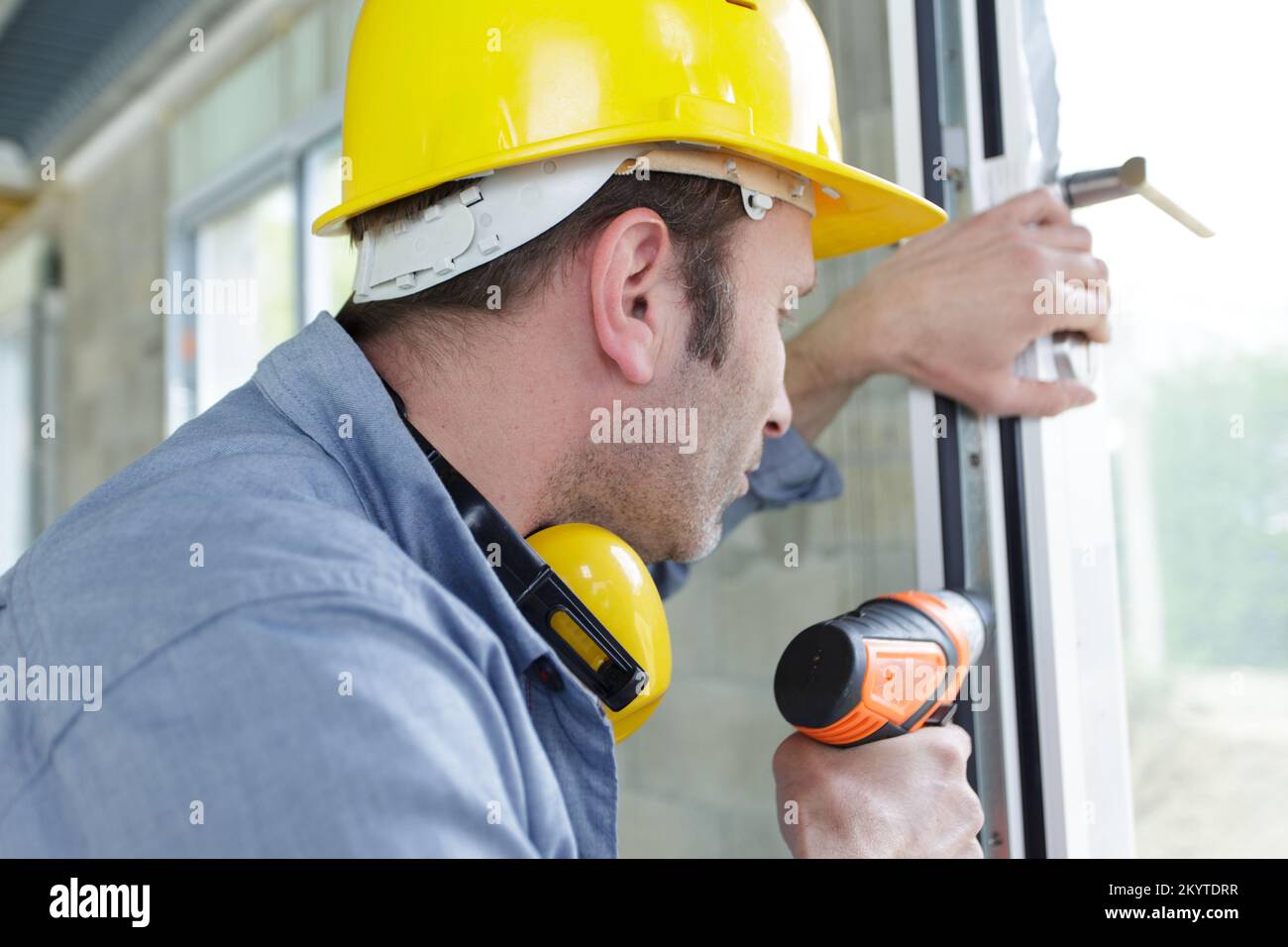 male builder using cordless drill on window Stock Photo - Alamy